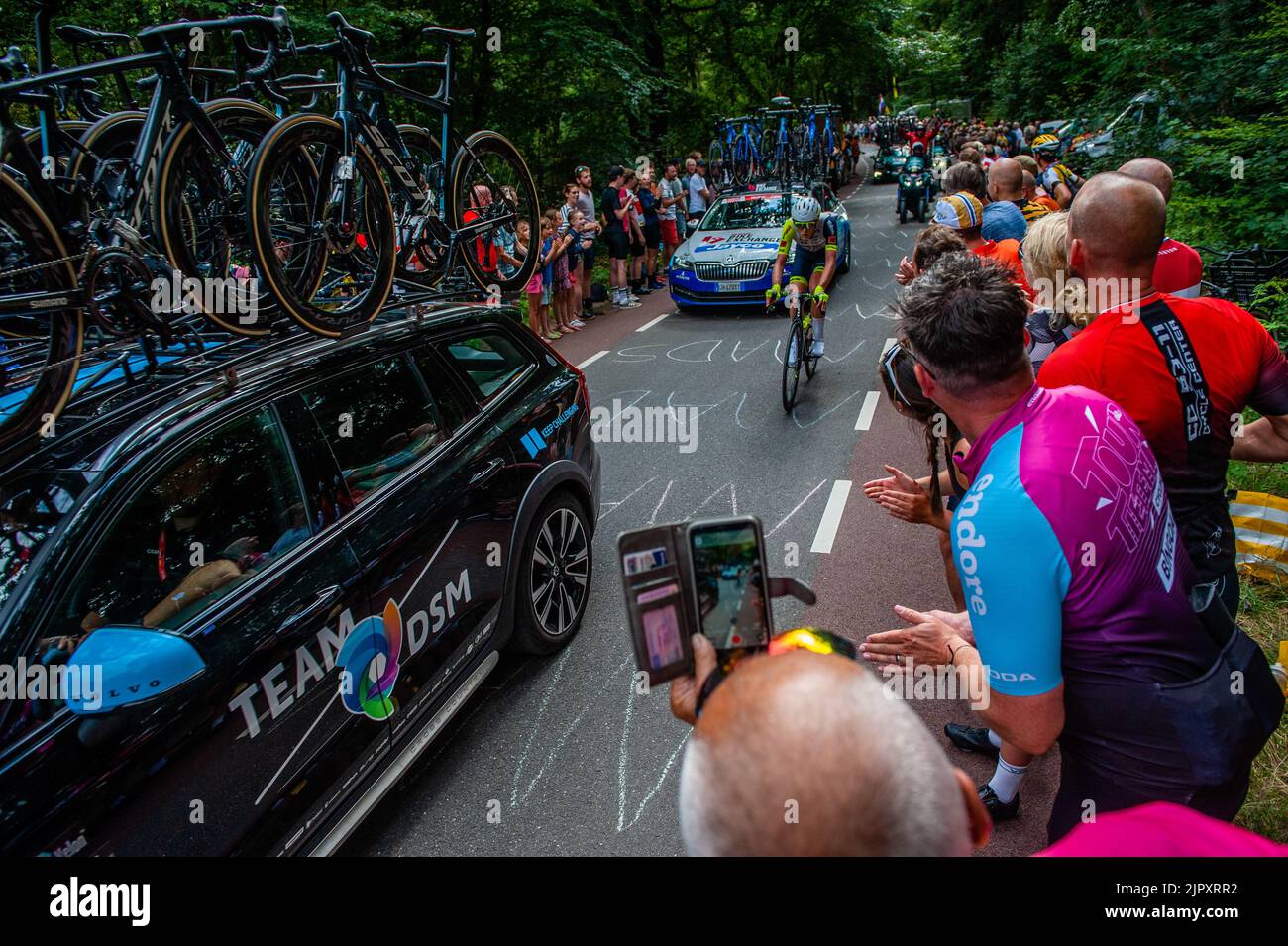 People are seen taking photos of the riders passing by. The peloton set ...