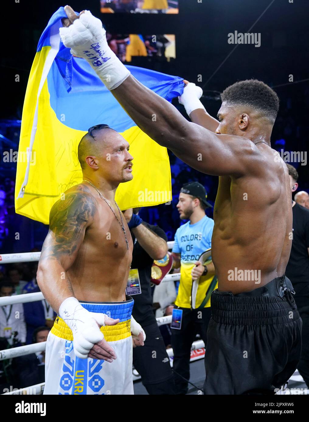 Anthony Joshua (right) holds up a Ukrainian flag as he speaks to Oleksandr Usyk at the end of ...