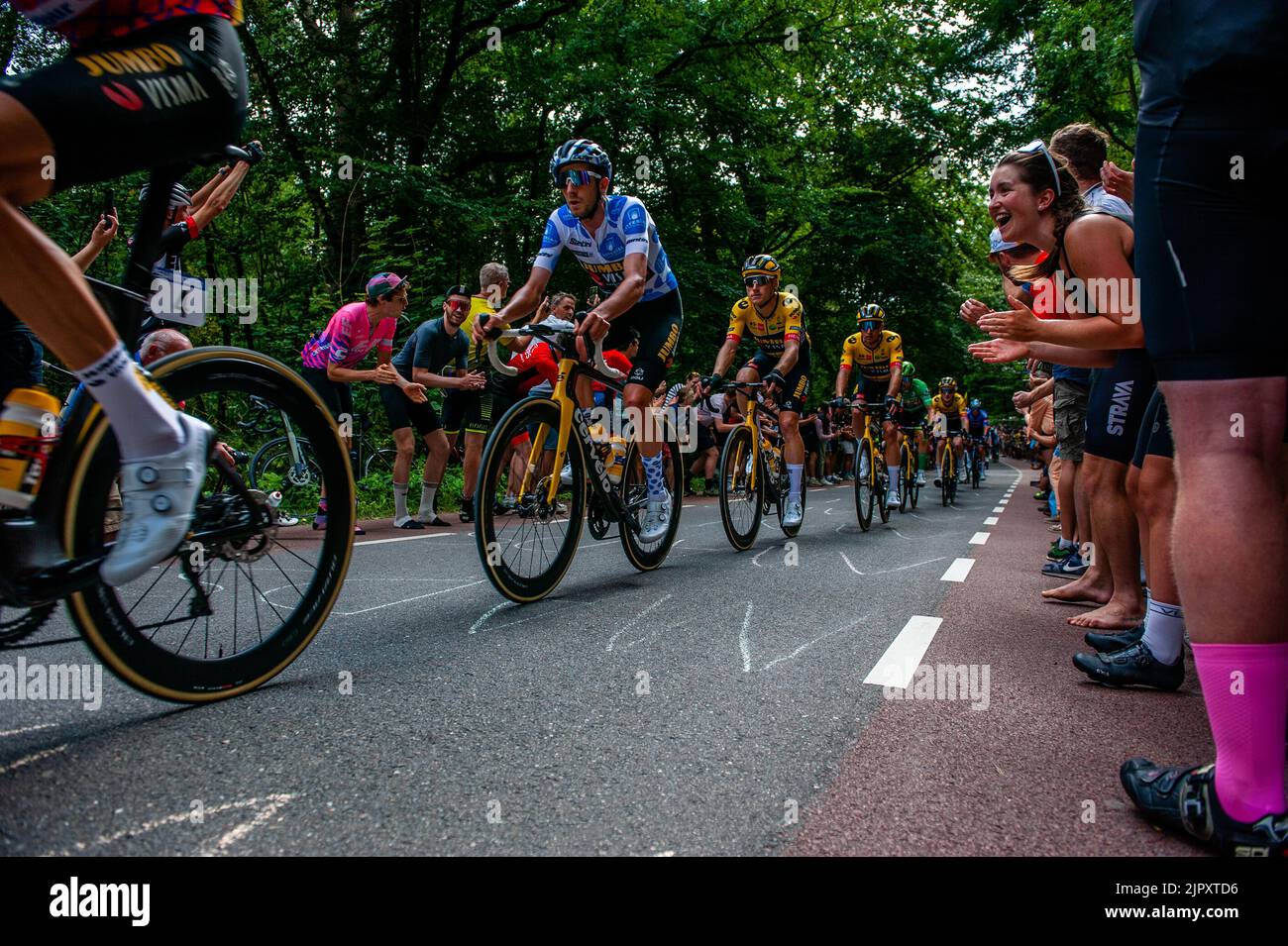 People are seen cheering the peloton passing by. The peloton set off ...