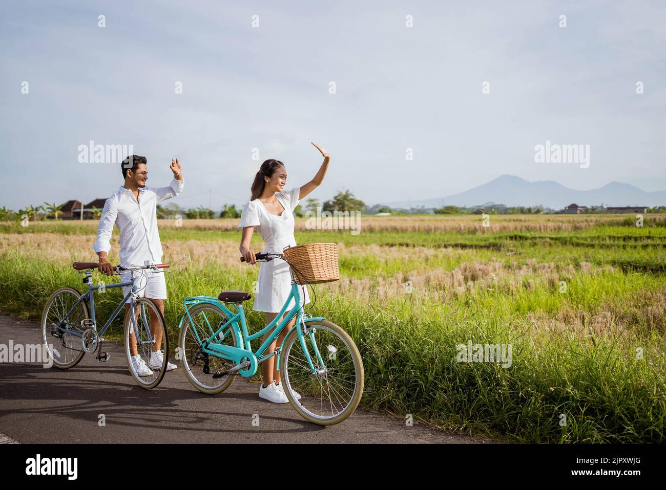romantic couple push their bike as they are walking on the road Stock Photo - Alamy