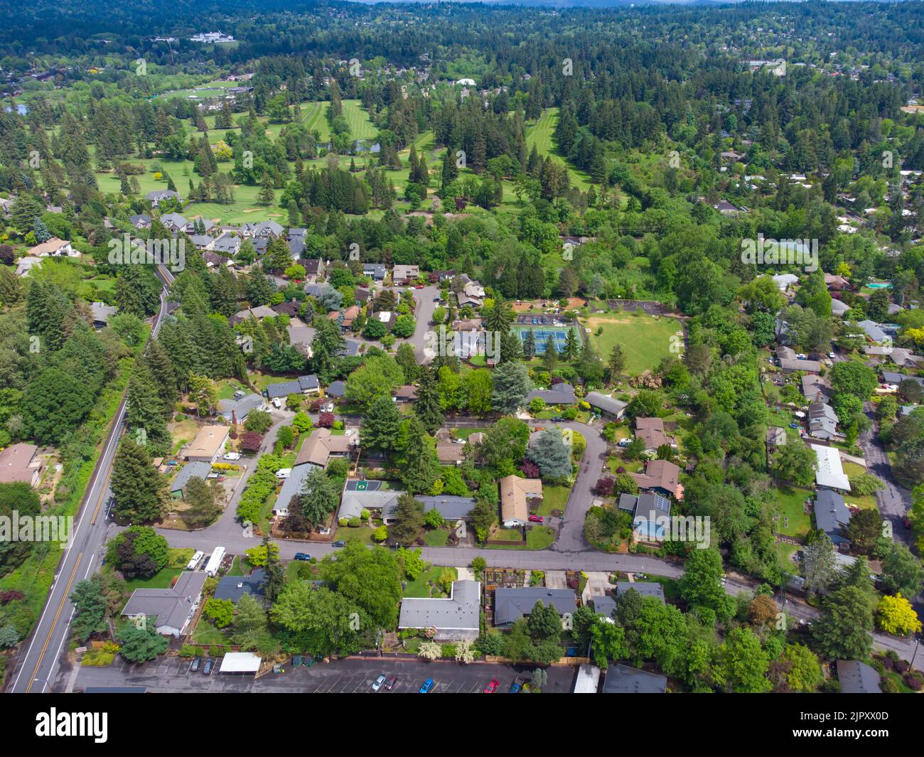 Aerial view of a green town located in a valley near a mountain range ...