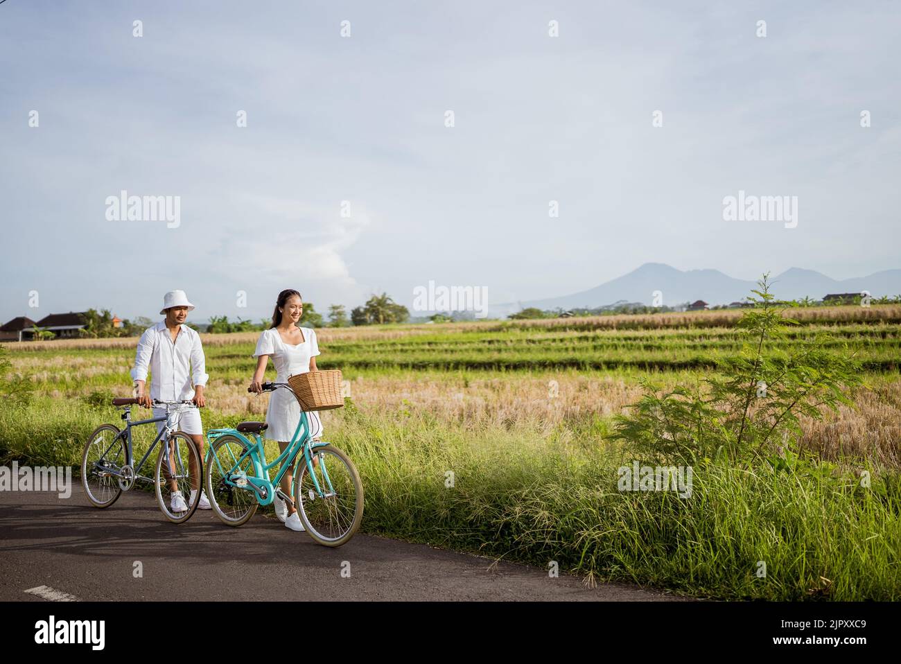 romantic couple push their bike as they are walking on the road Stock Photo - Alamy