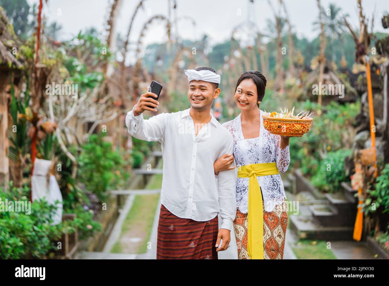 balinese couple in traditional clothing take self portrait Stock Photo ...