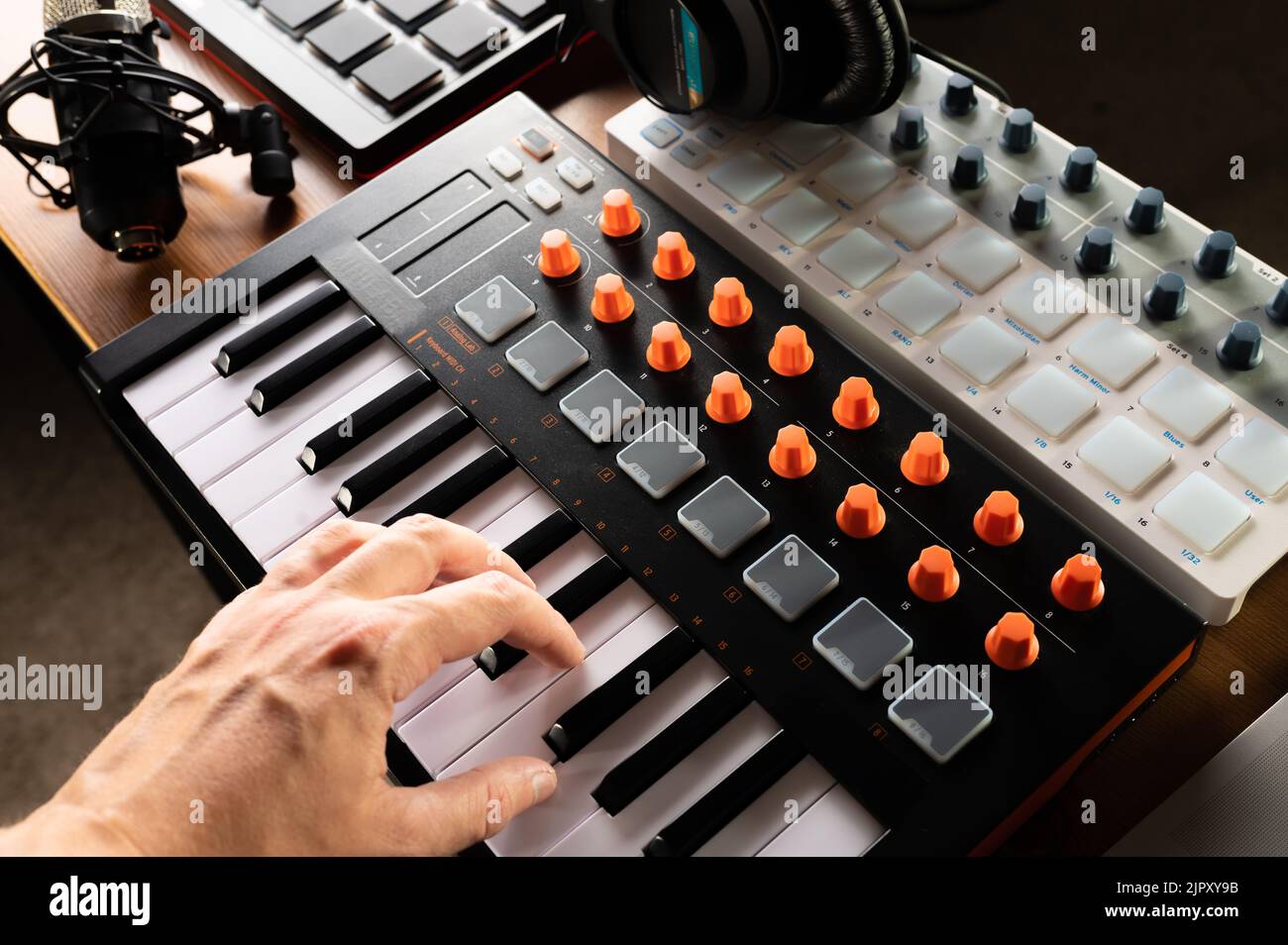 Close-up. Man's hand on the keys of a midi keyboard. Modern studio ...