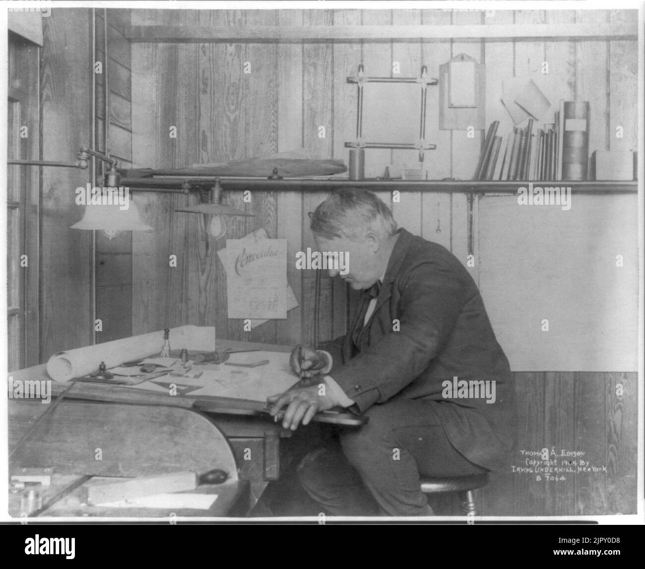Thomas Alva Edison, 1847-1931, left profile, seated at his desk ...