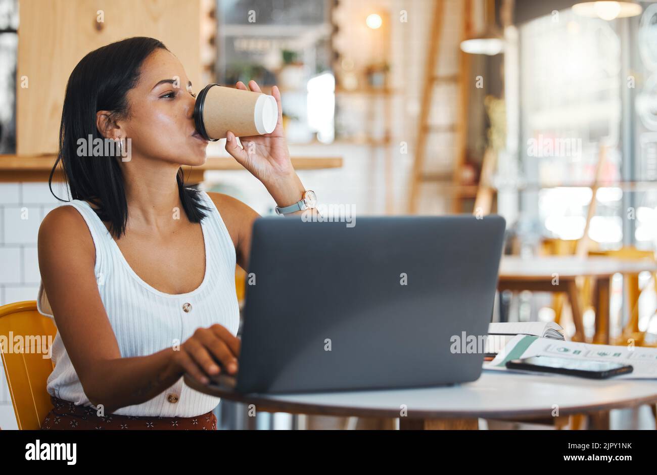 Entrepreneur drinking tea while working on laptop at cafe, woman ...