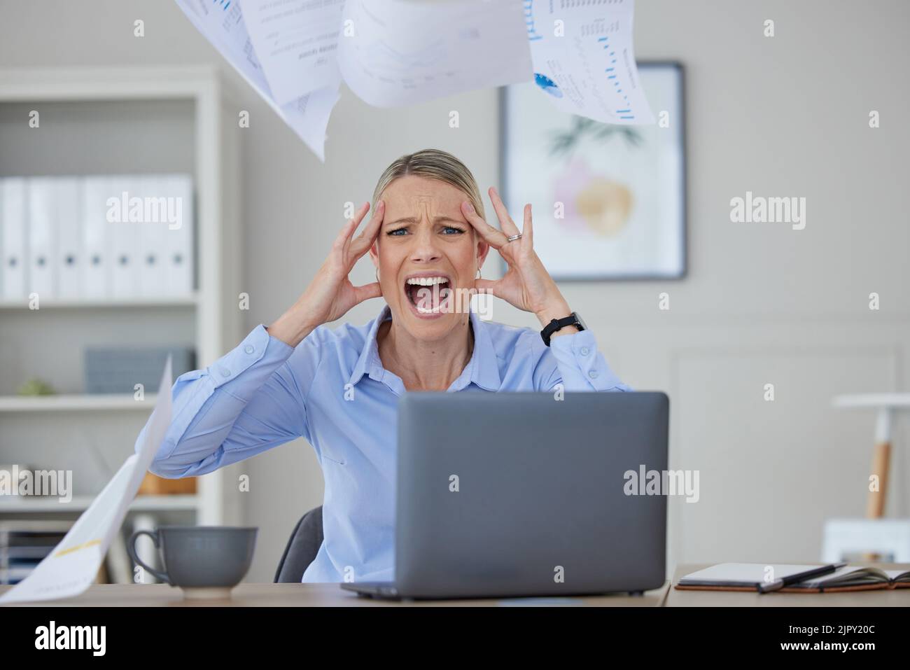 Angry, stress and woman screaming at her office desk in frustration and ...