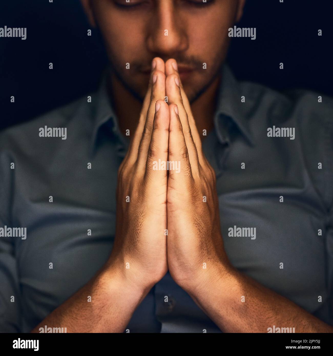 Give us this day our daily bread. Closeup shot of a young man praying ...