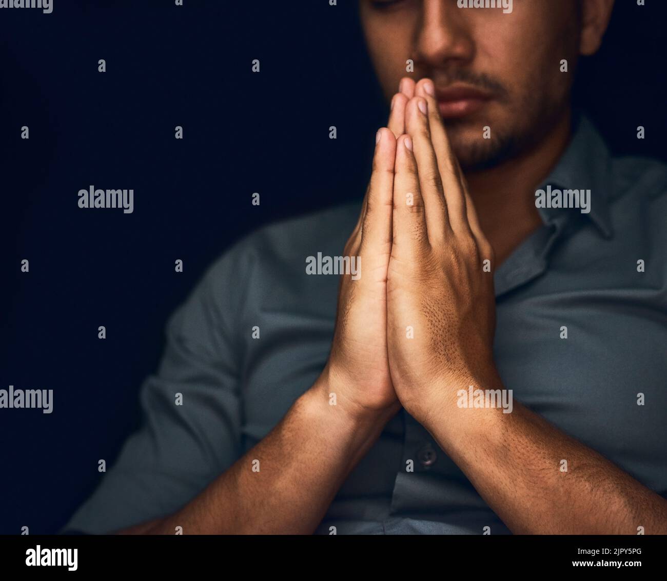Give us this day our daily bread. Closeup shot of a young man praying ...