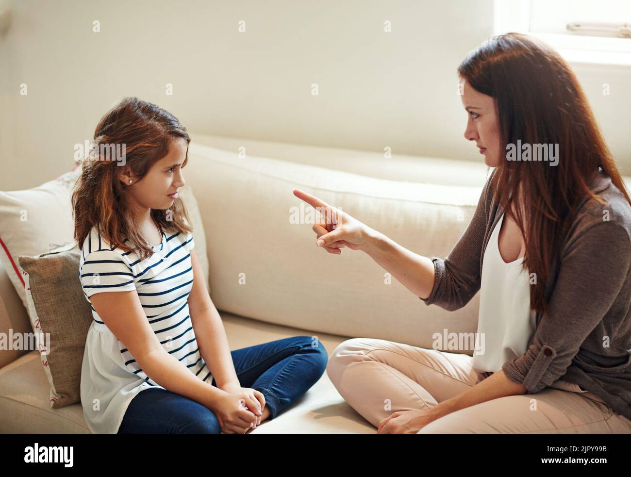 Discipline starts at home. a young girl being reprimanded by her mother ...