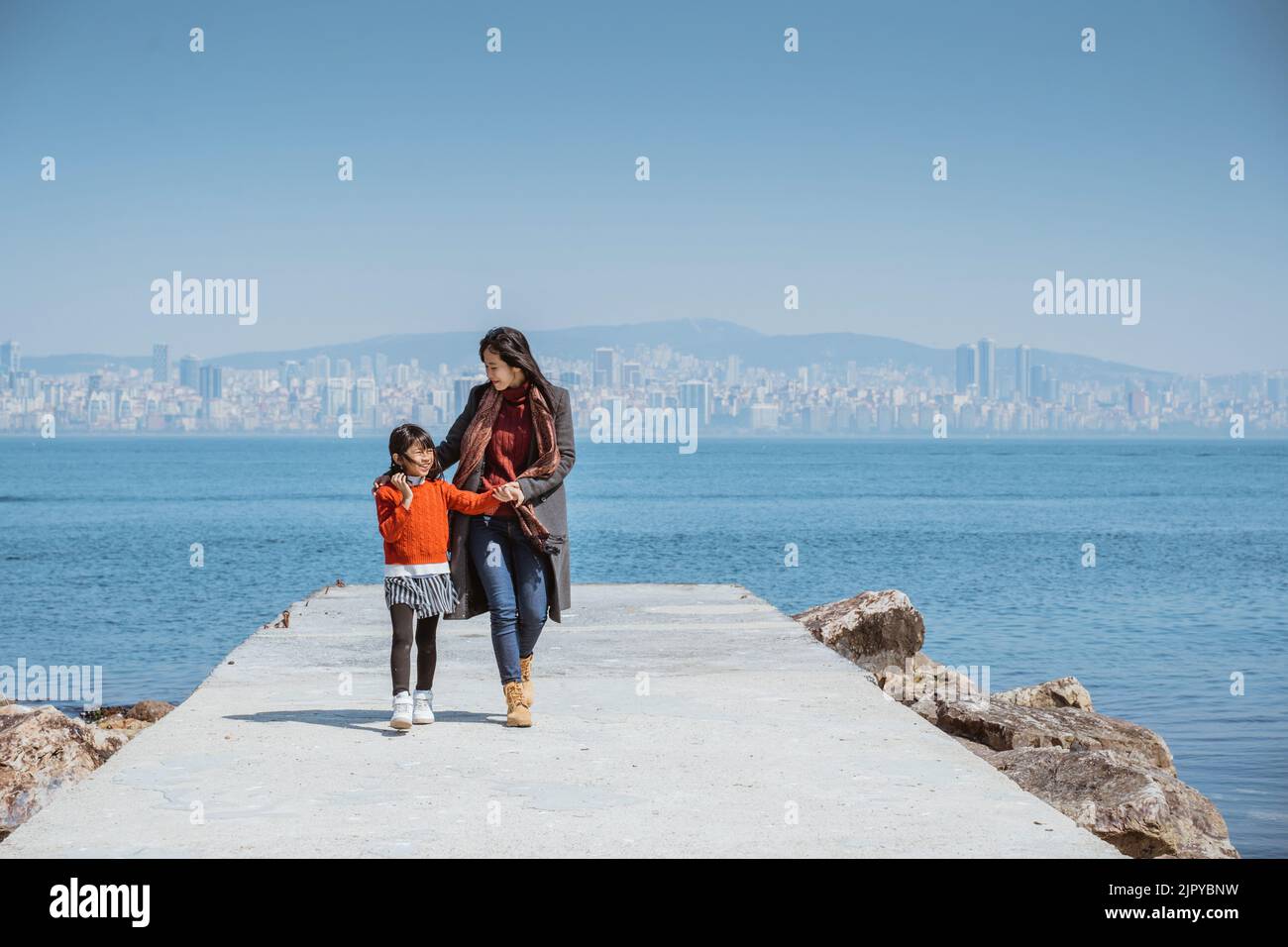 mother and daughter walking together on a ferry dock Stock Photo - Alamy