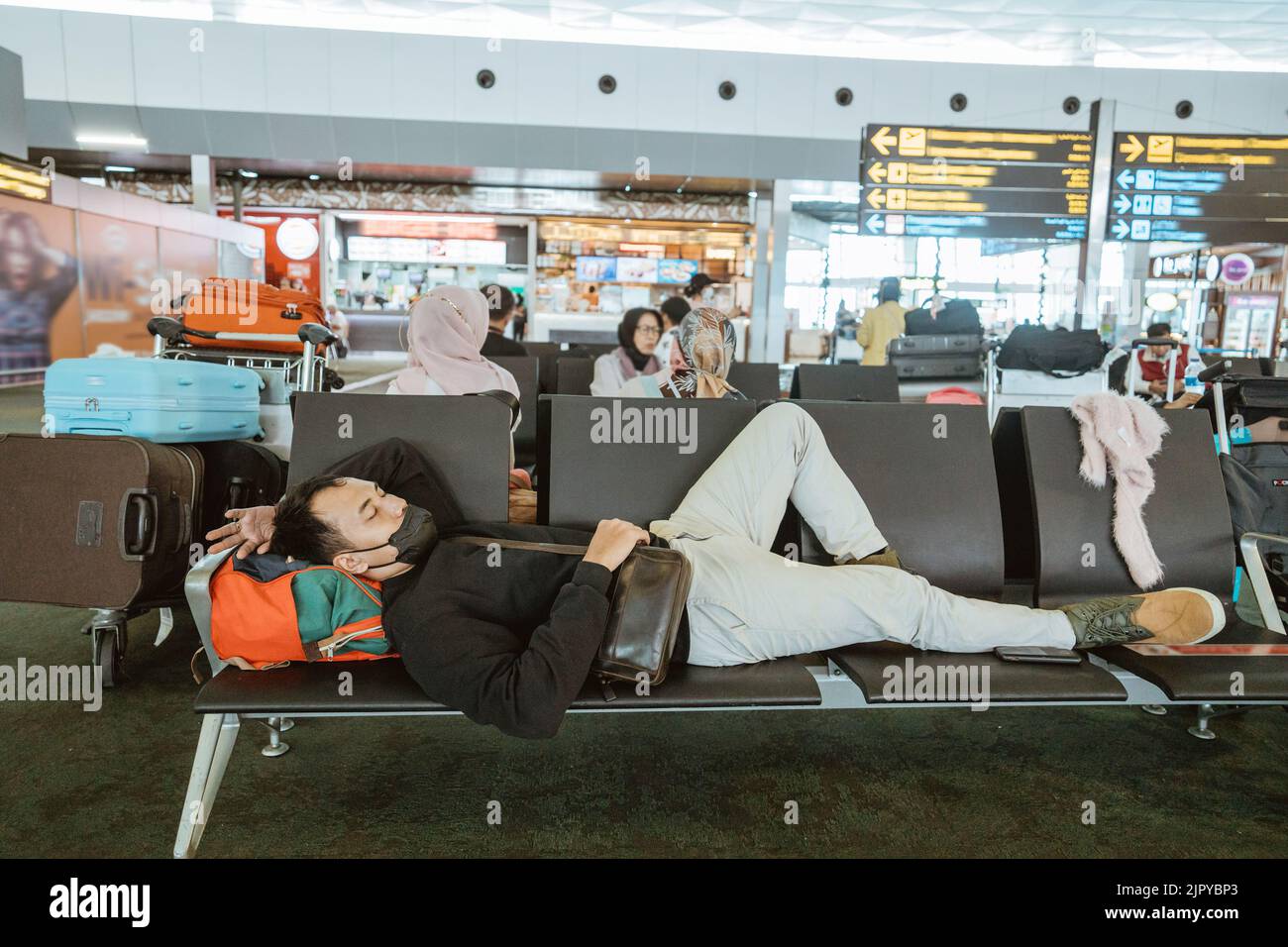 tired man laying on a bench at the airport terminal Stock Photo - Alamy