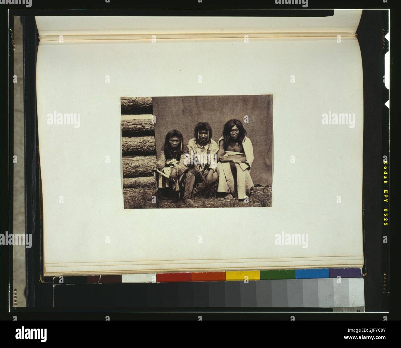 Three Kootenai men, full-length portrait, seated against blanket in ...