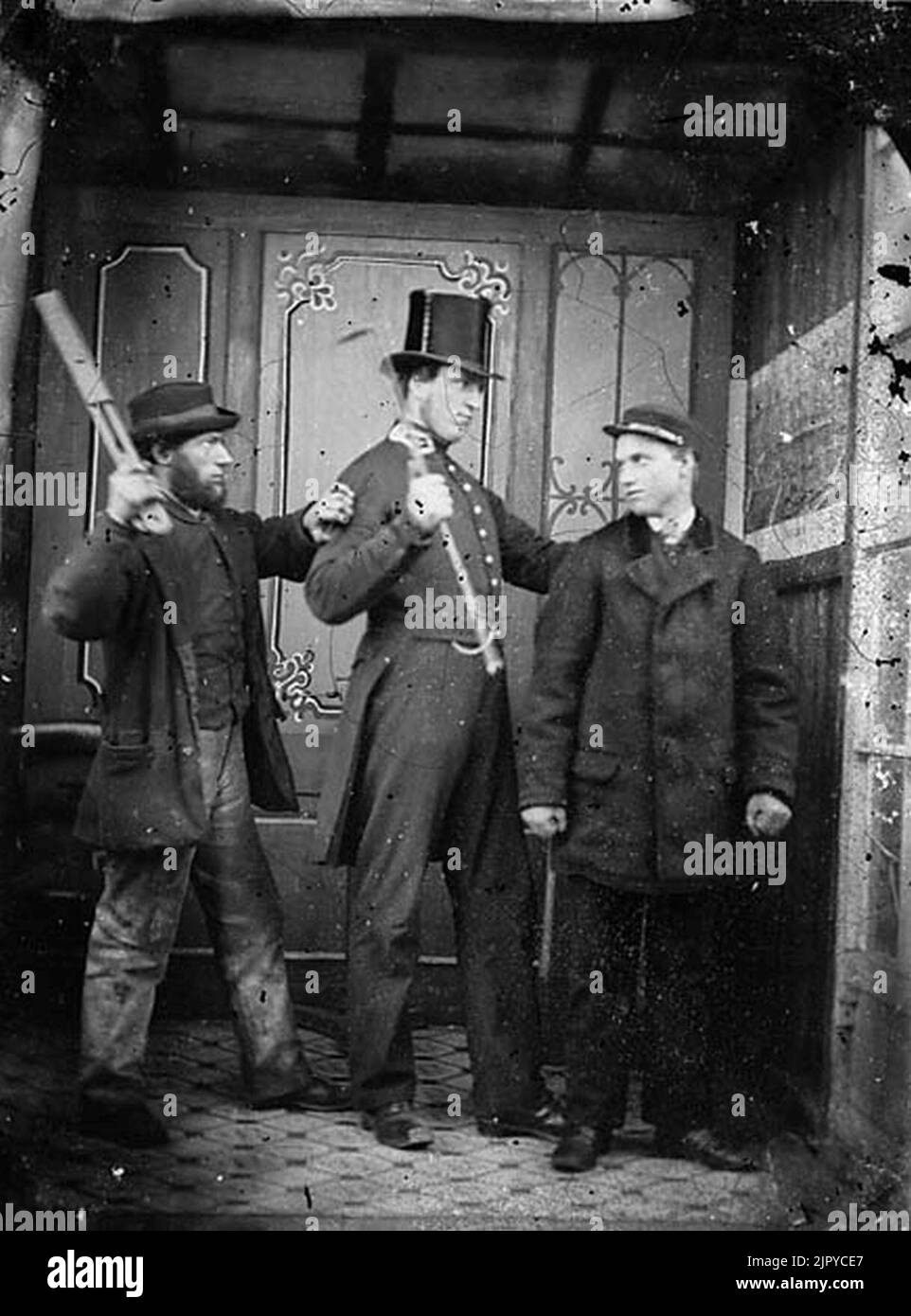 Three men, one dressed as a policeman Stock Photo - Alamy