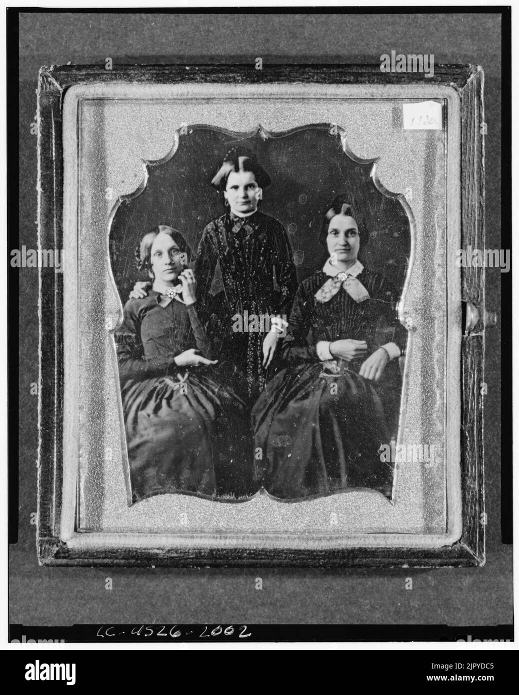 Three unidentified women, two seated, one standing, facing front Stock ...