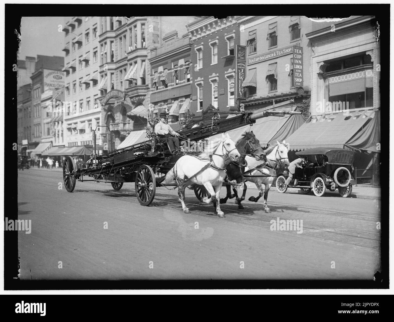 Three-horse team fire truck with water tower passing the 1300 block of ...
