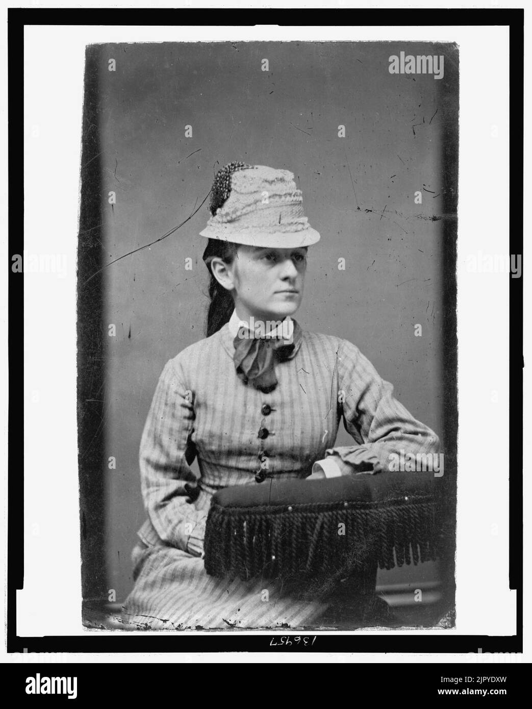 Three-quarter length portrait of a woman seated, wearing a flower pot ...
