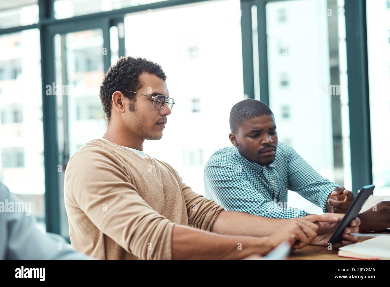 Getting their deadlines done together. two young designers working on a ...