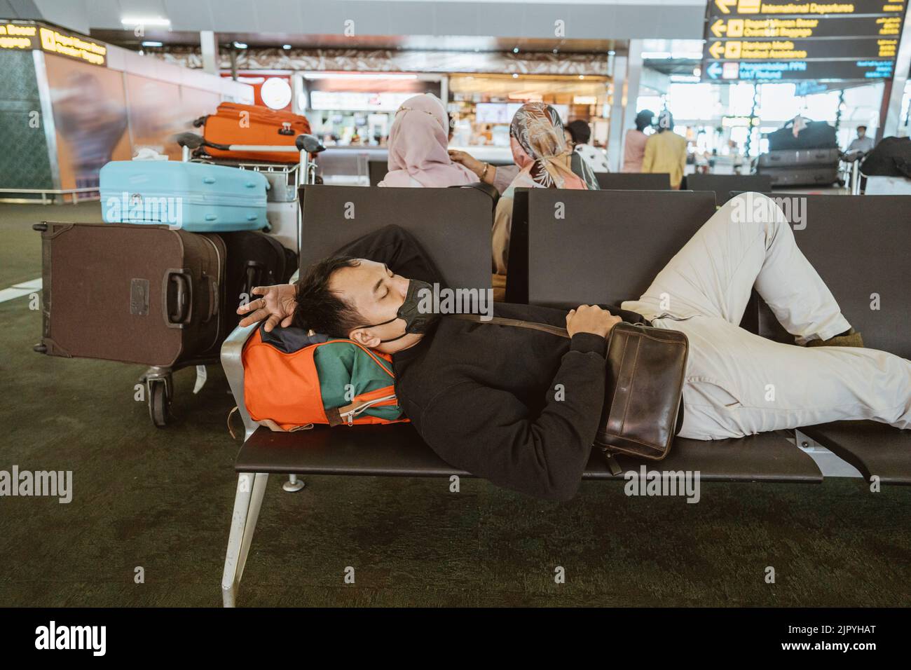 tired man laying on a bench at the airport terminal Stock Photo - Alamy