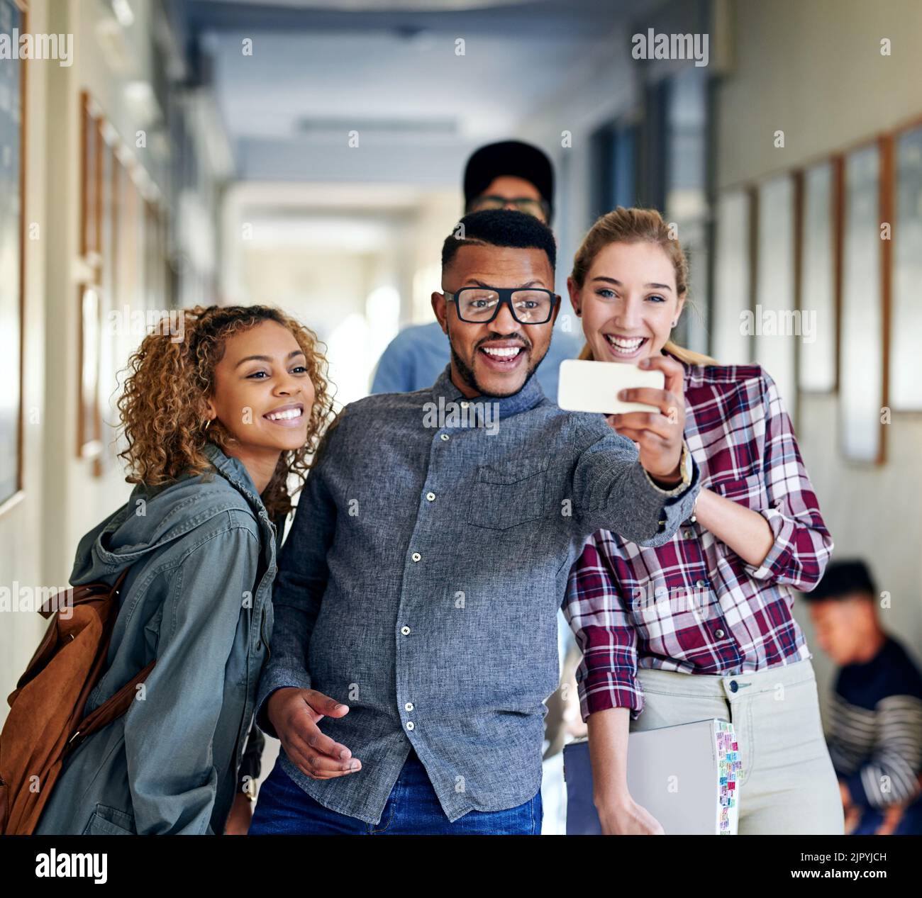 Lets take a selfie. a group of young university students taking selfies ...