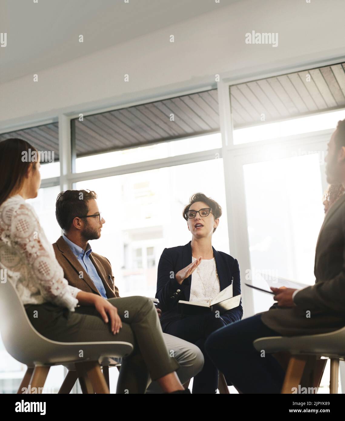 Making her point clear. a group of corporate businesspeople sitting in ...