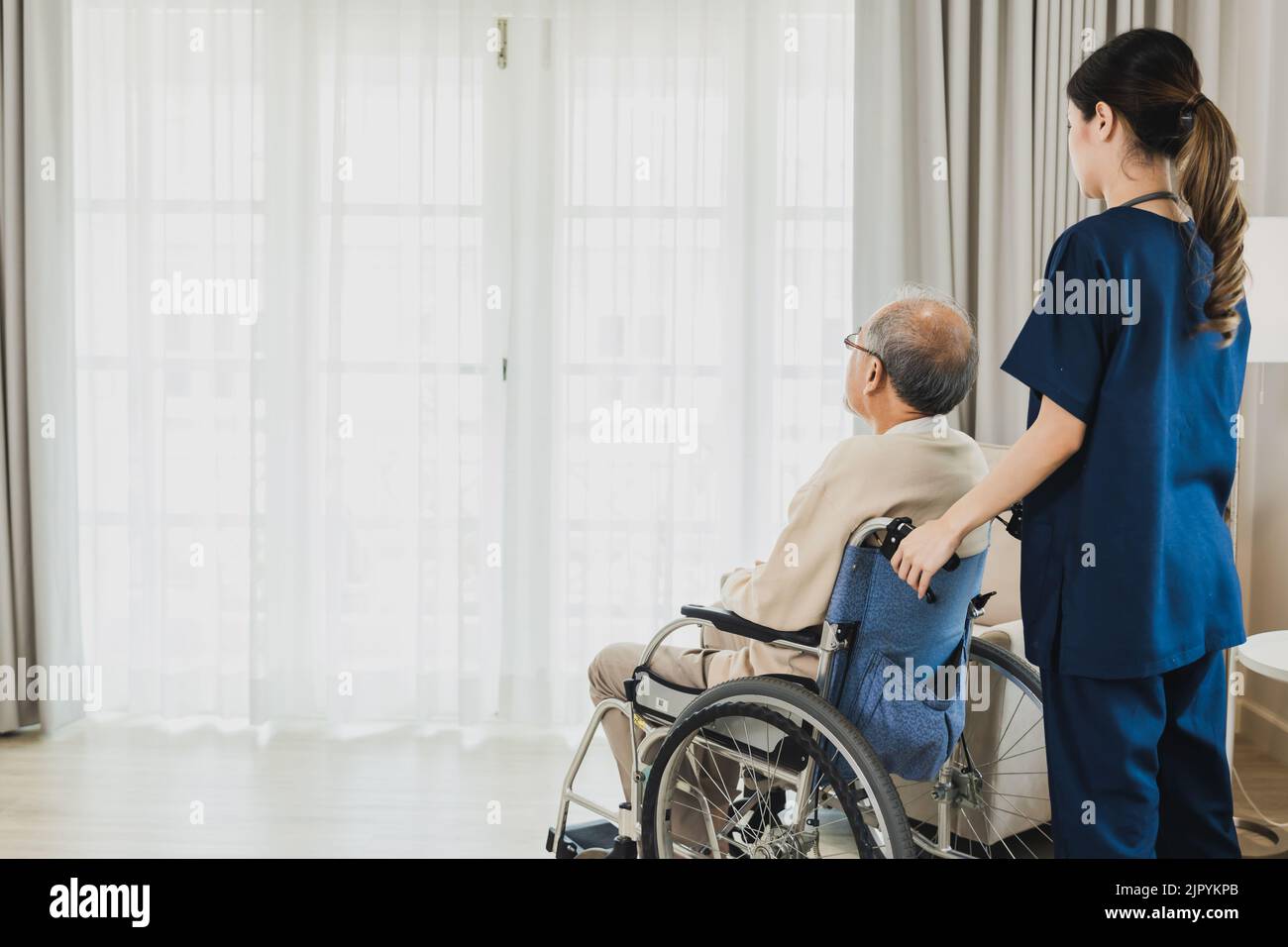 Senior Asian man in wheelchair receives medical help for injury, take ...