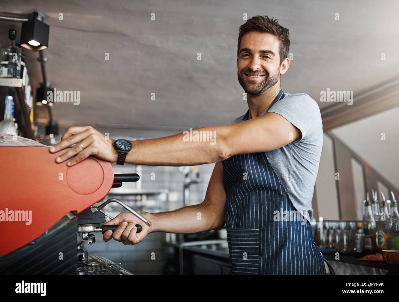 He puts passion into every cup. a young man operating the coffee ...