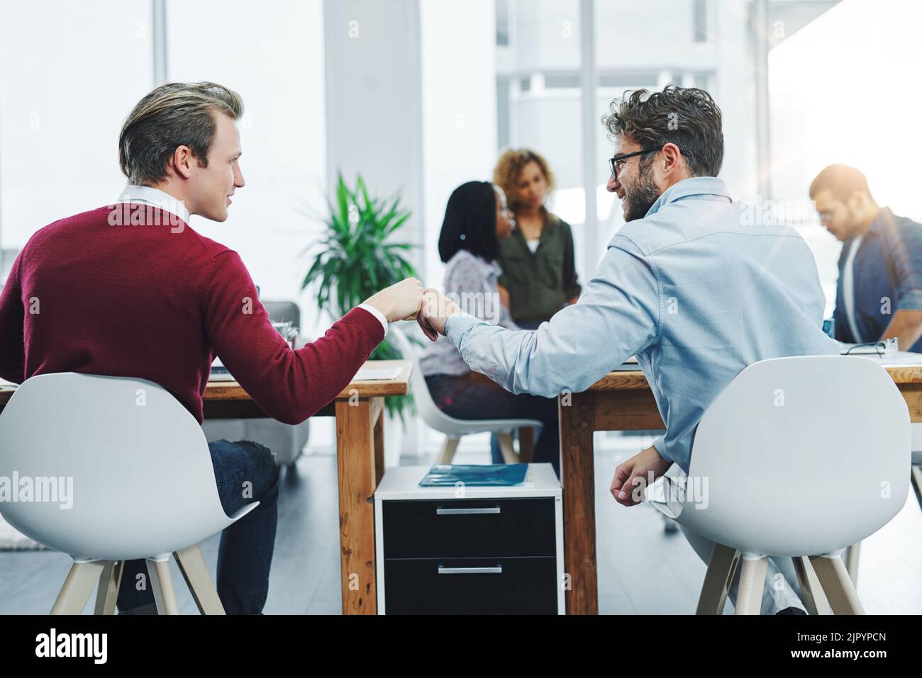 Support each others success. two young colleagues giving each other a ...