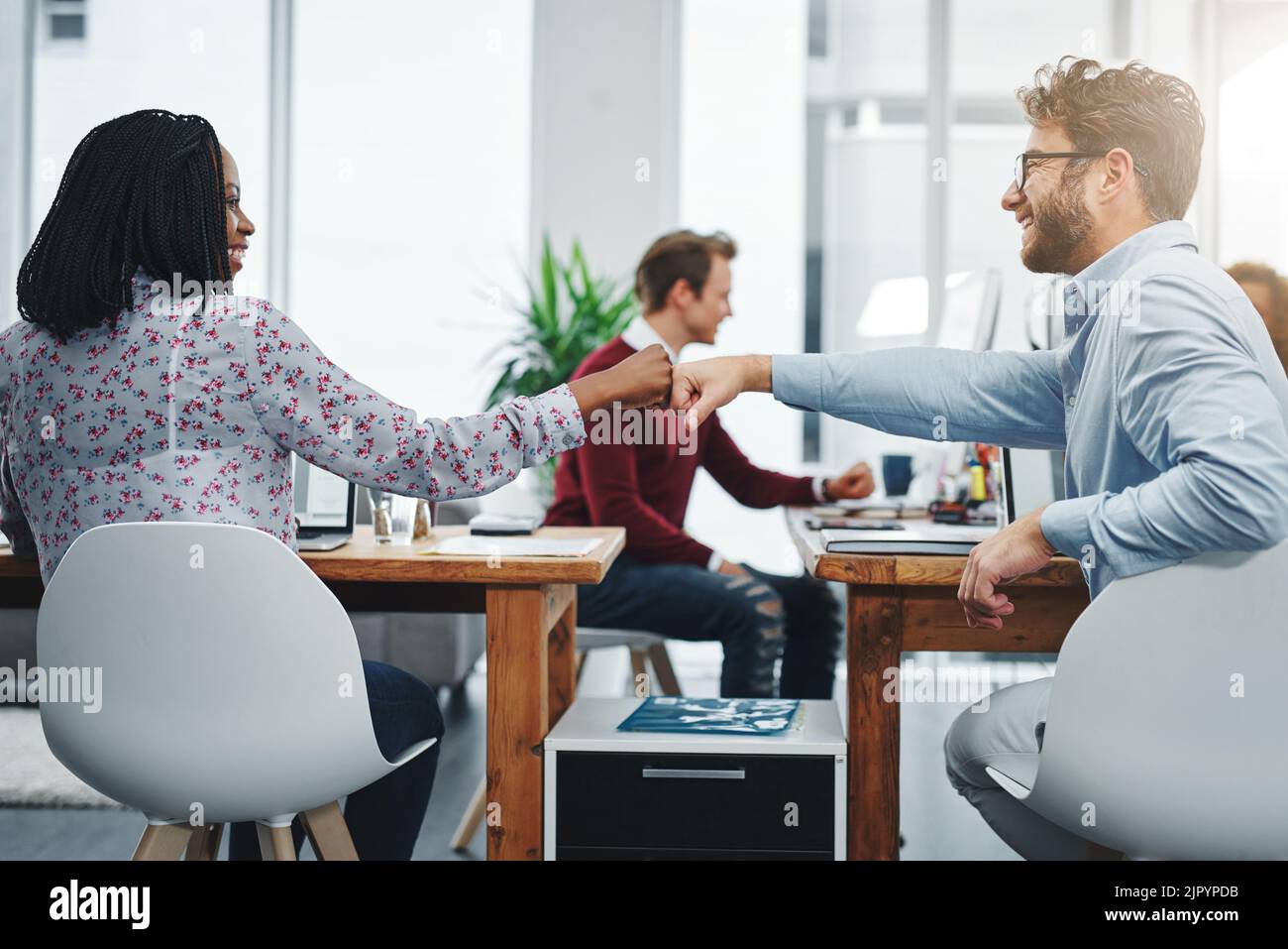 Thats another win for us. two young colleagues giving each other a fist ...