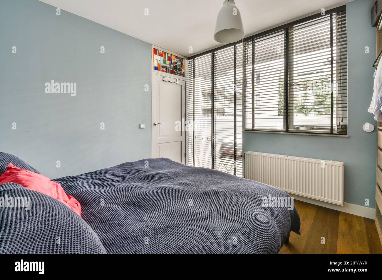 Home interior design of bedroom with bed and wooden wardrobe placed in ...