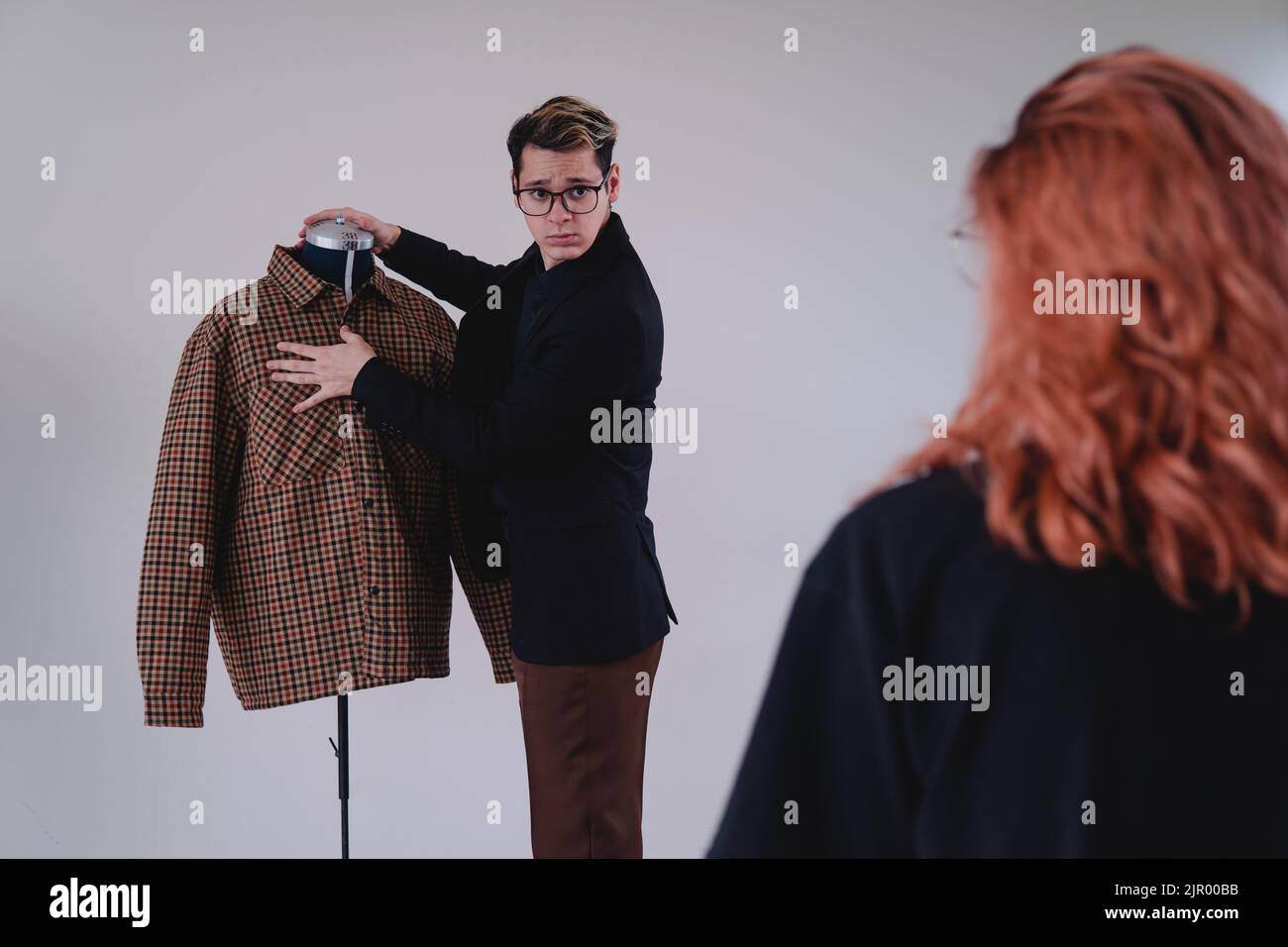 Fashion designer presenting his garment. Male designer presenting a ...
