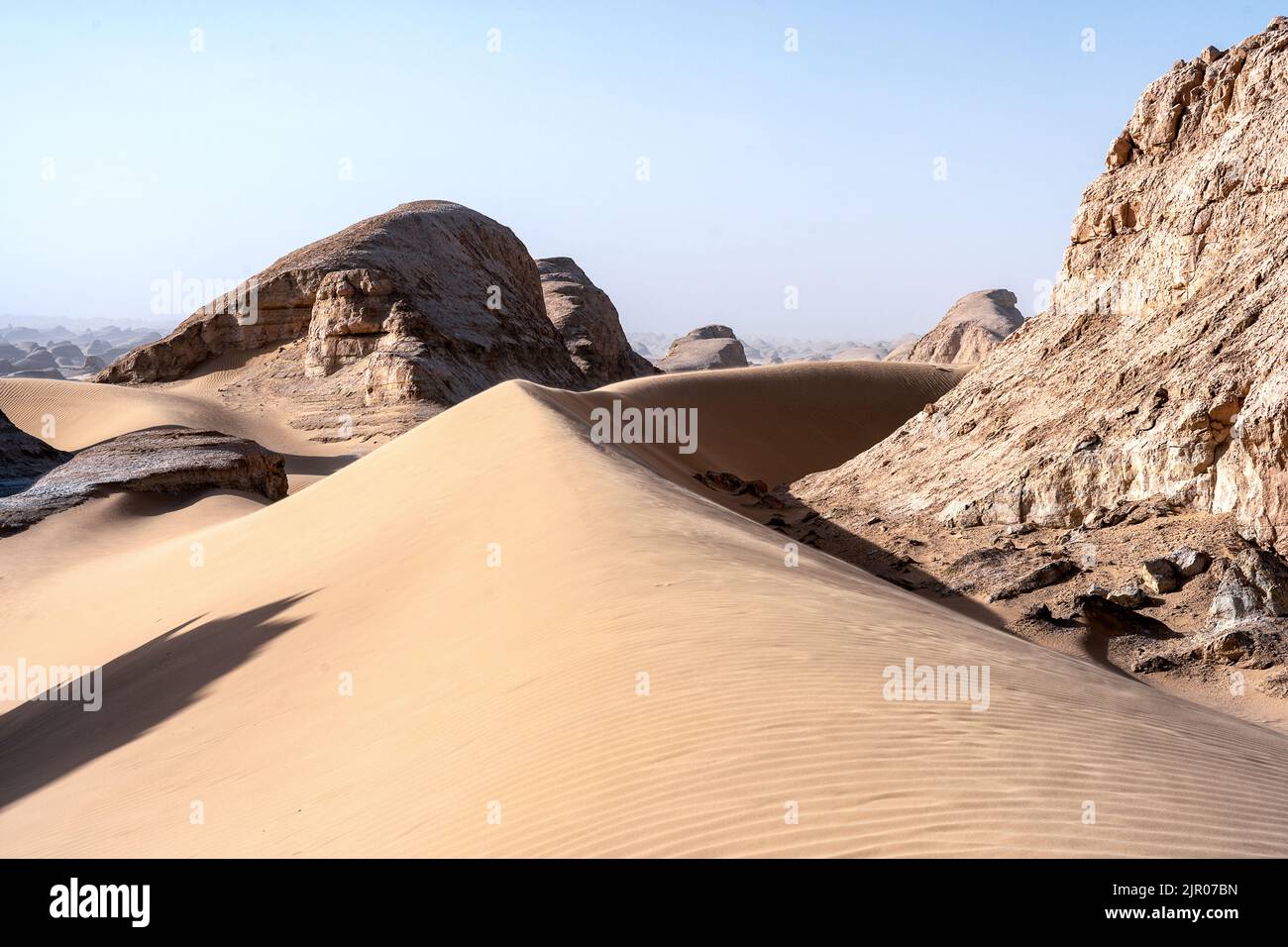 A scenic view of sand dunes surrounded by rock formations on a ...