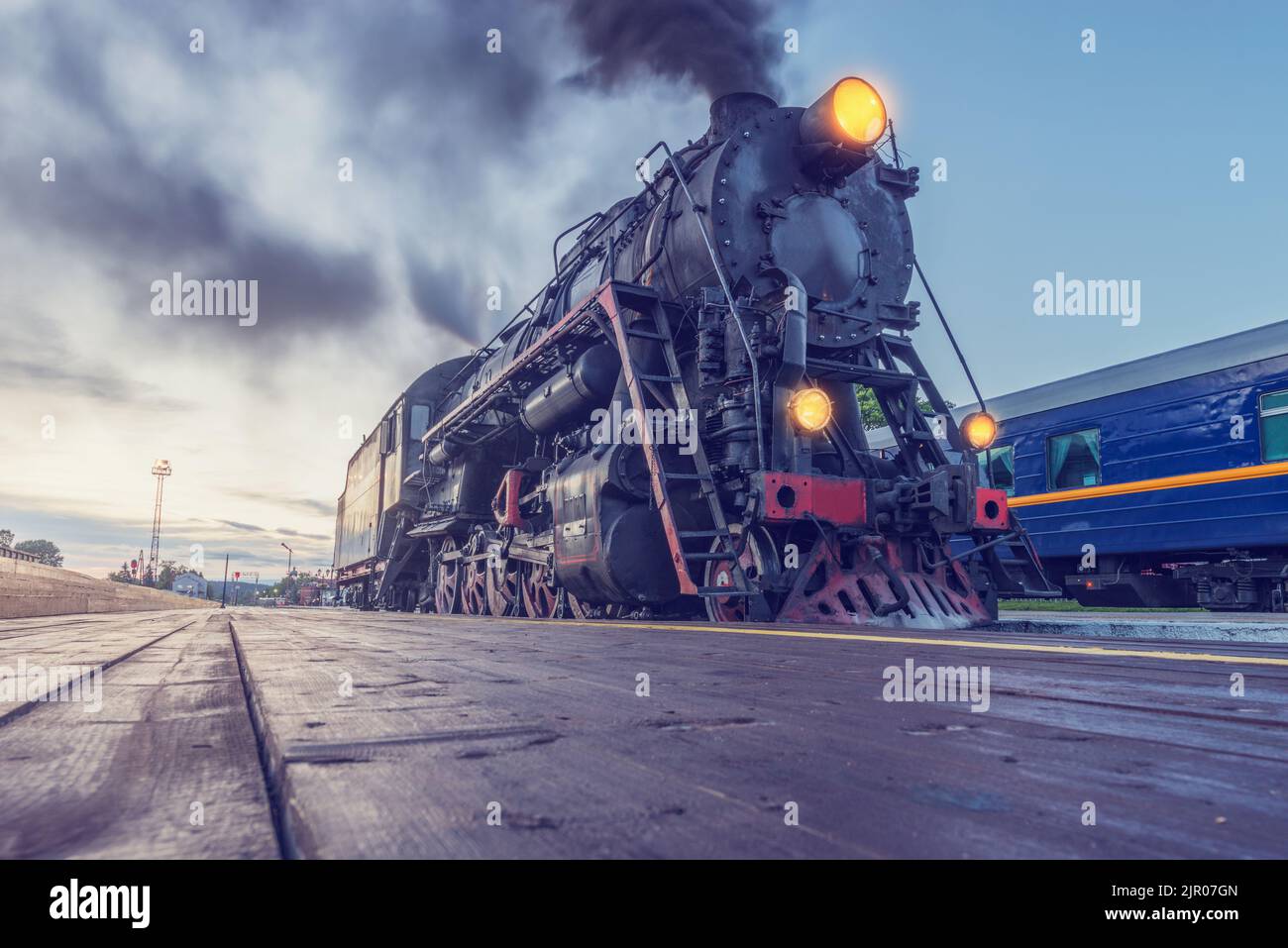 Steam locomotive stands by the wooden station platform at sunrise Stock ...
