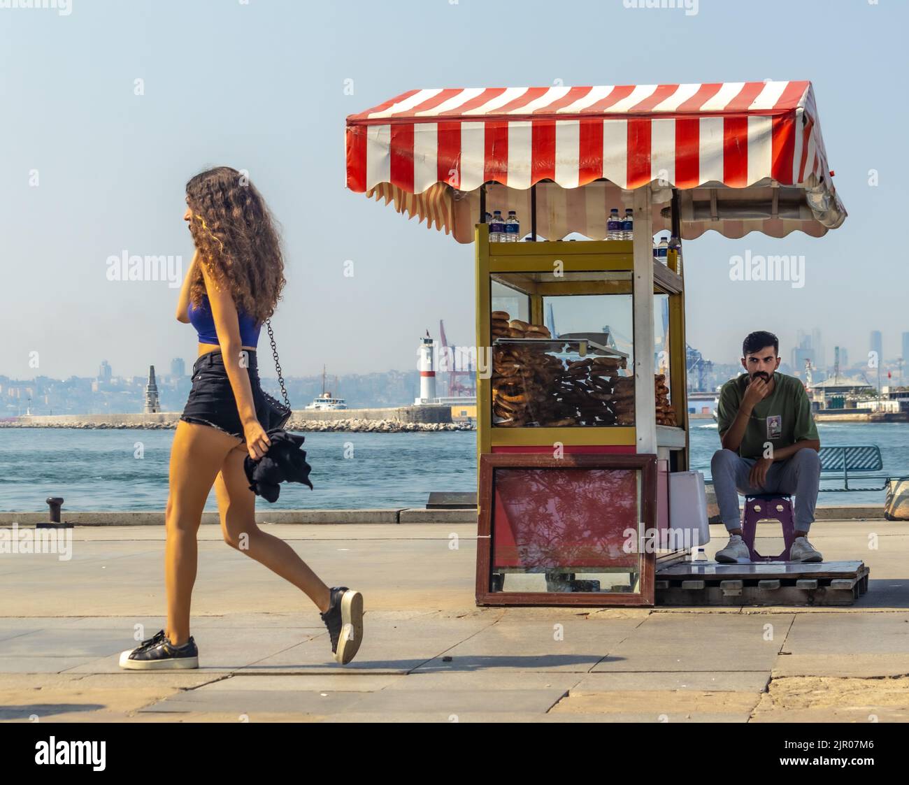 Kadikoy shore Istanbul summer, simit seller surreptitiously watches ...