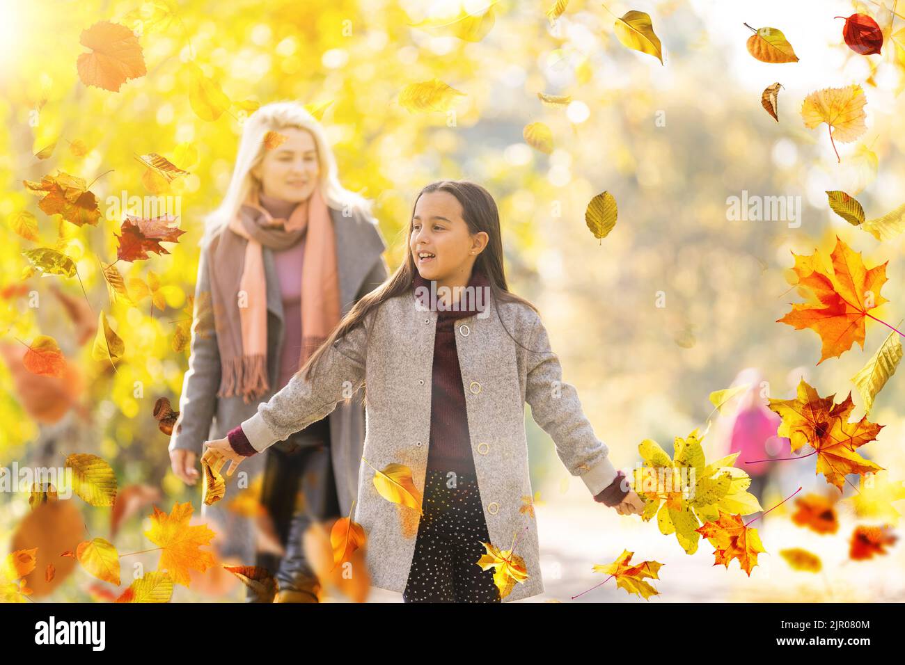happy family: mother and child little daughter play cuddling on autumn ...