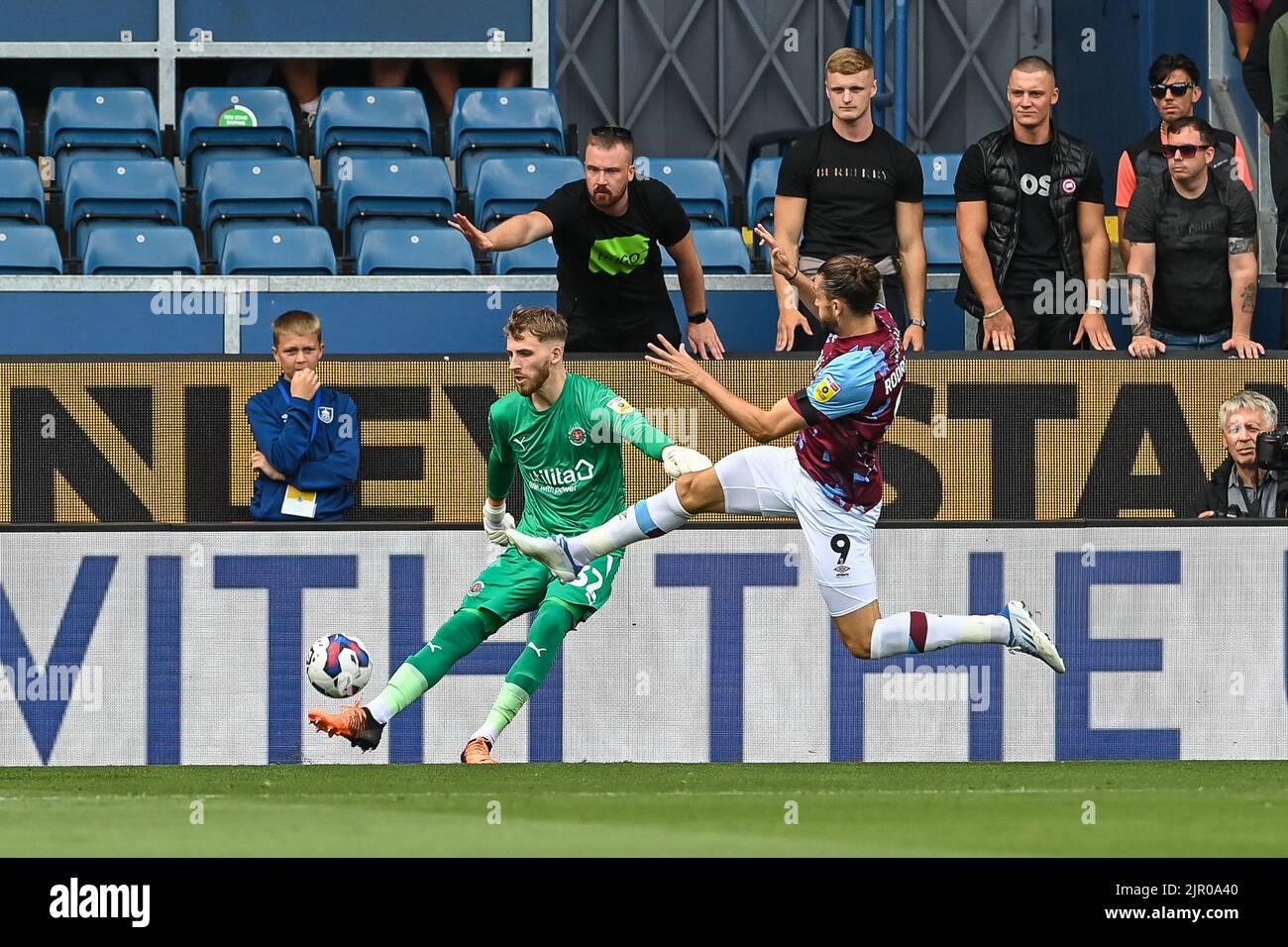 Daniel Grimshaw #32 of Blackpool clears the ball despite pressure from ...