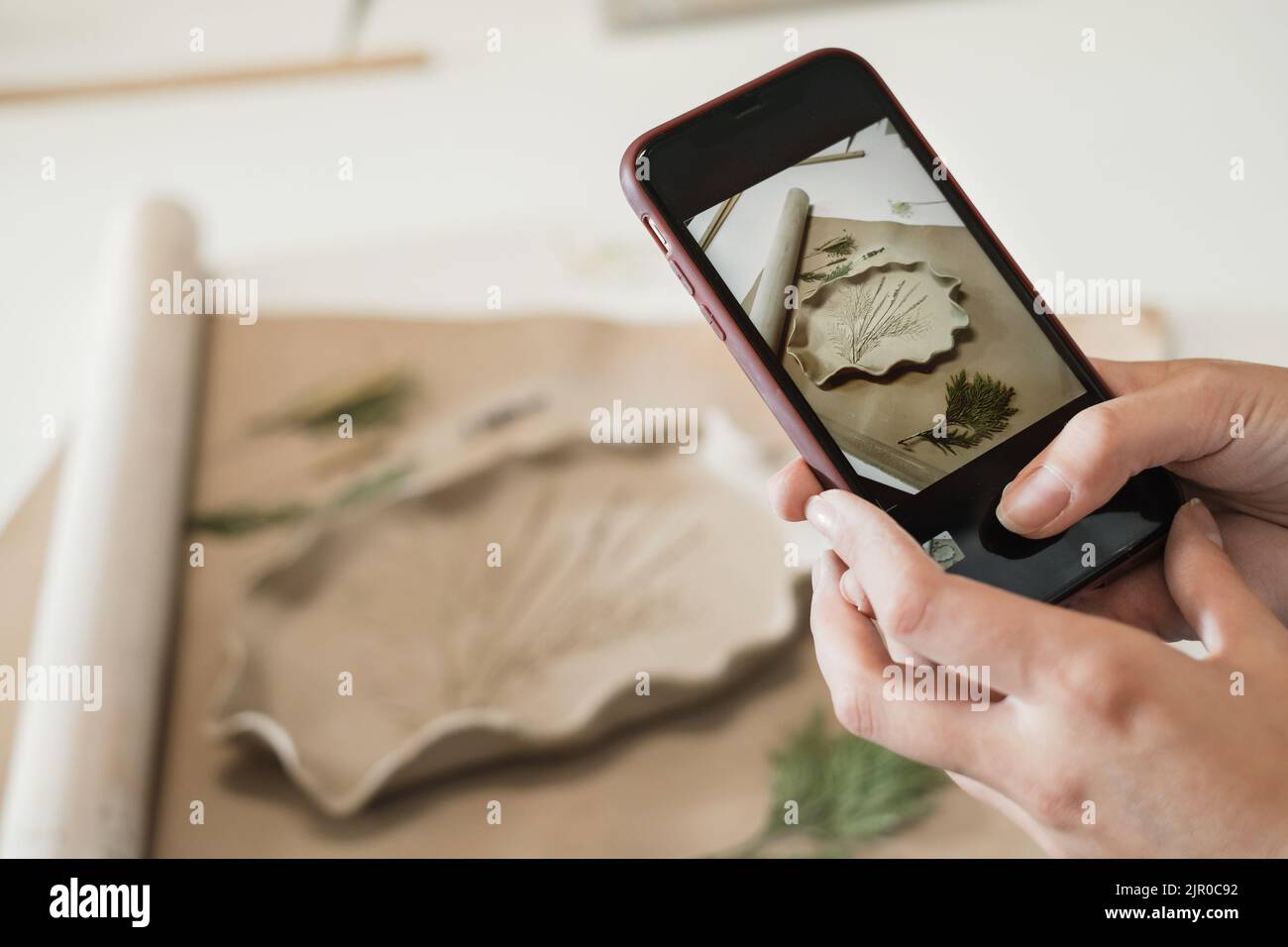 Taking picture of handmade ceramics on workshop. Pottery blog owner ...