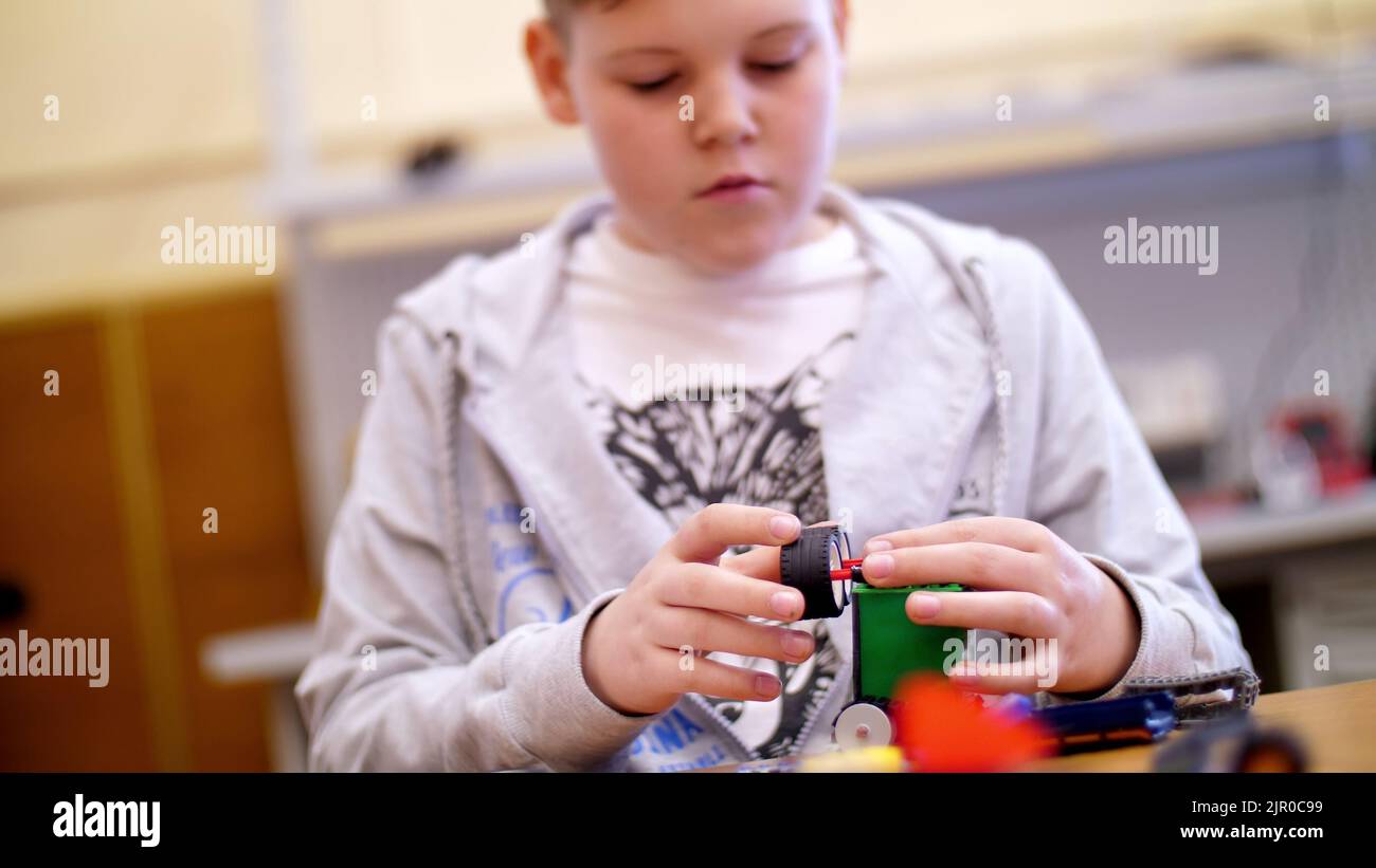 the boy of 11 years, plays in the designer from cubes, plates, circuits ...