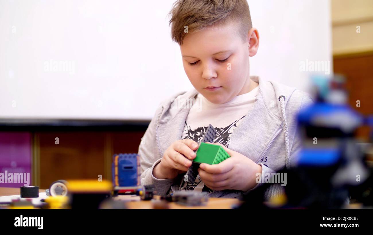 the boy of 11 years, plays in the designer from cubes, plates, circuits ...