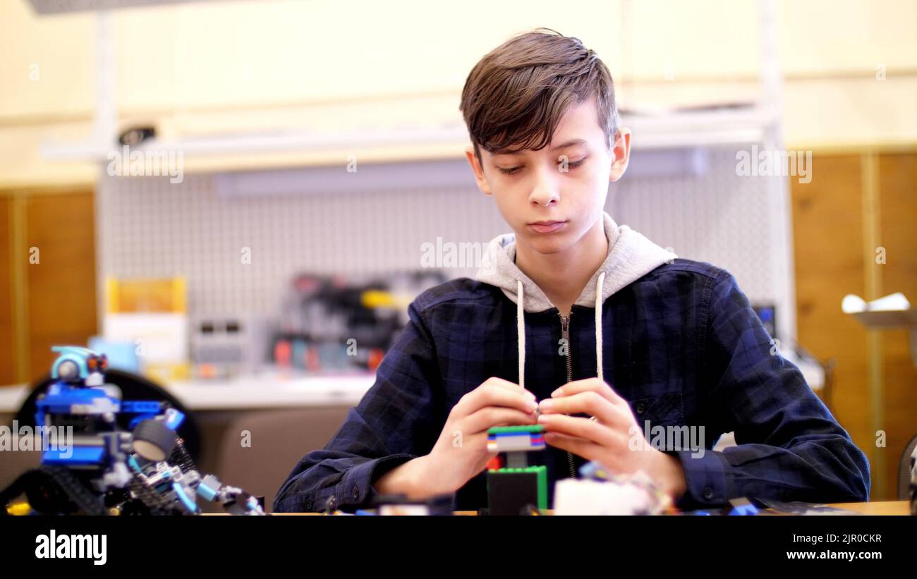 the boy of 12 years, plays in the designer from cubes, plates, circuits ...