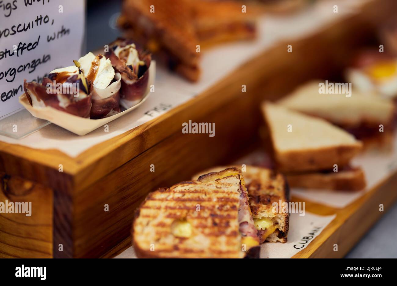 A closeup shot of tasty dessert and a crispy sandwich in a food market ...