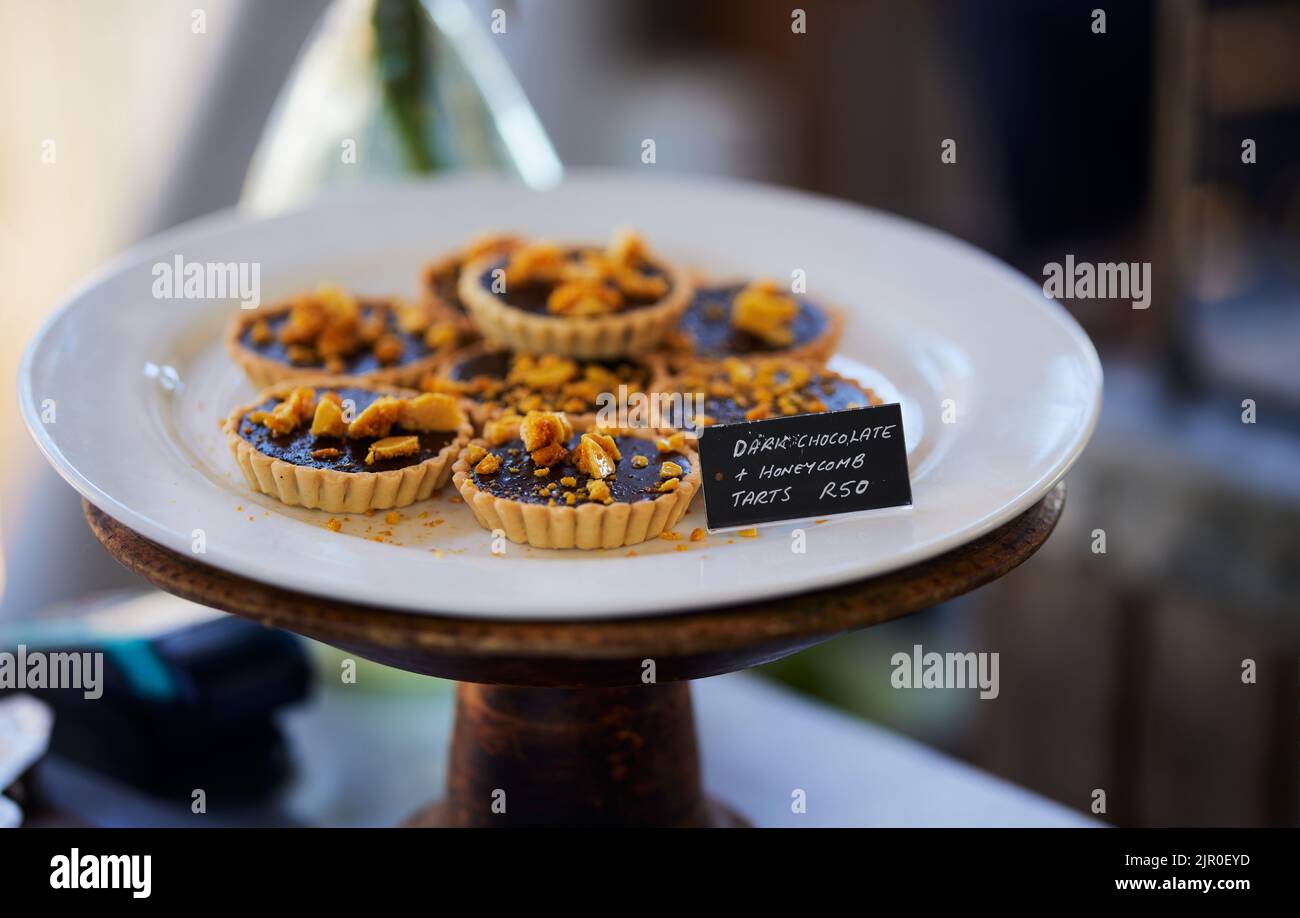 A plate with tarts baked with dark chocolate and honeycomb in a food ...