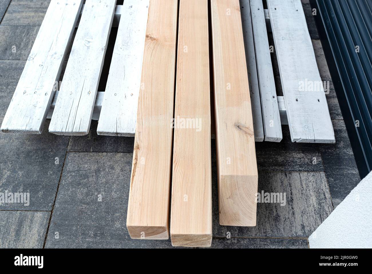 Raw planed pine wooden beams, dimensions 100x100mm, lying next to each ...