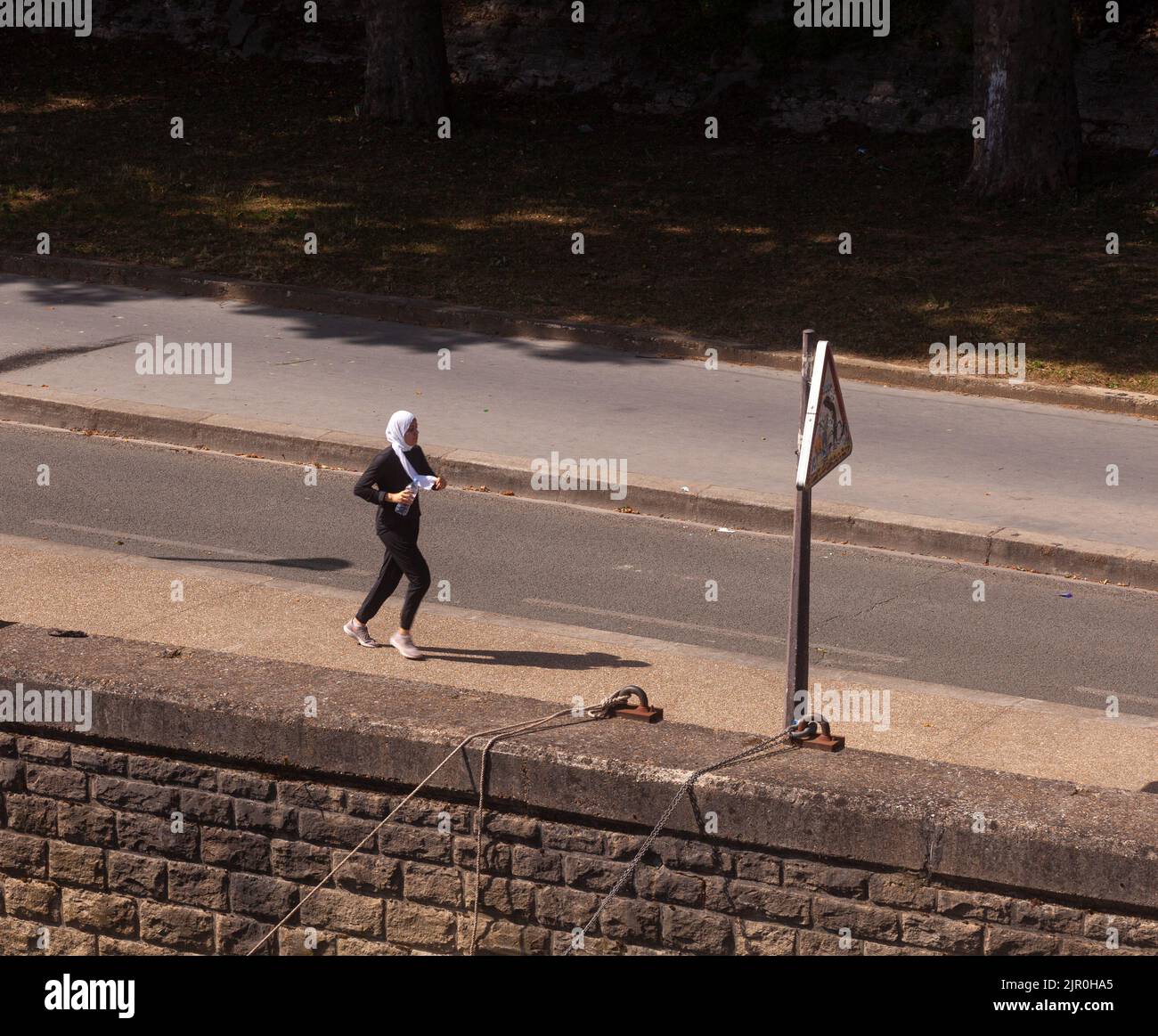 Paris, France - July, 14: Young Muslim sportswoman in hijab running on ...