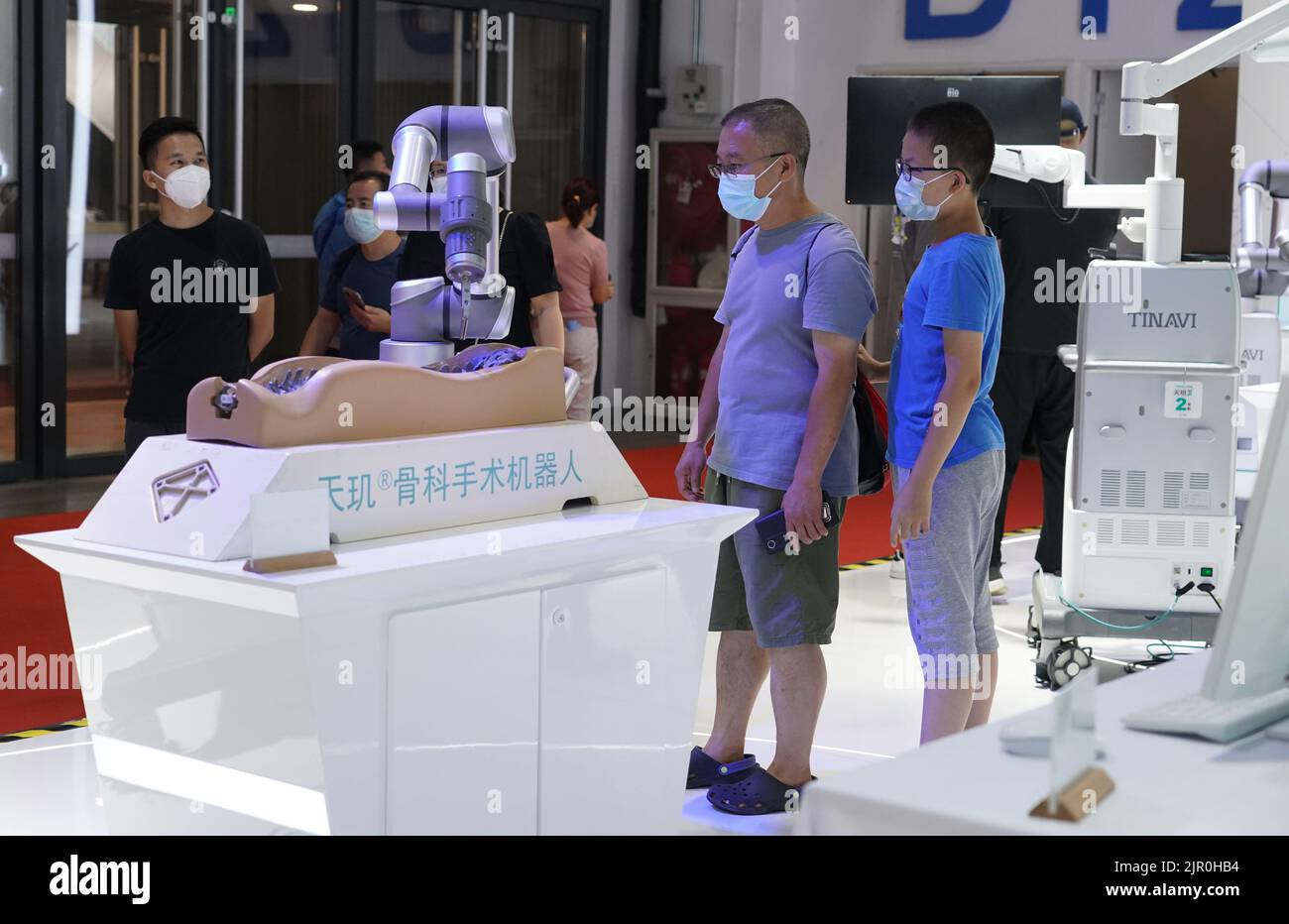Beijing, China. 20th Aug, 2022. Visitors look at a surgery robot at the ...