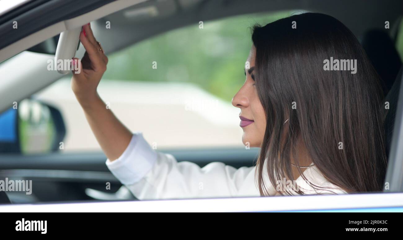 Adult woman driver opens mirror checking appearance in car Stock Photo ...