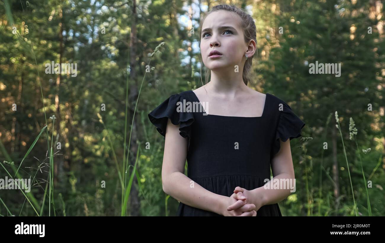 Scared girl looks around dark forest dreaming for help Stock Photo - Alamy