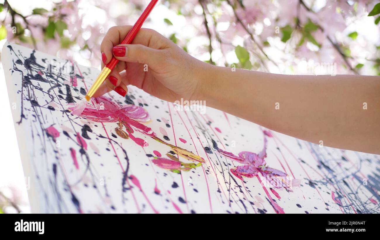 close-up, female hand, painter, artist paints a picture of flowers in ...