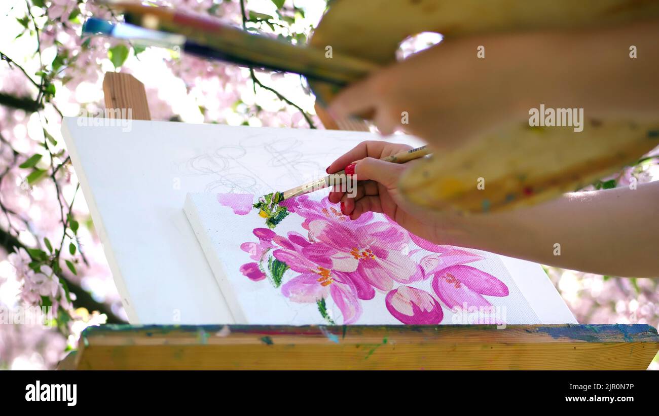 close-up, painter draw a picture of flowers in blooming spring apple ...