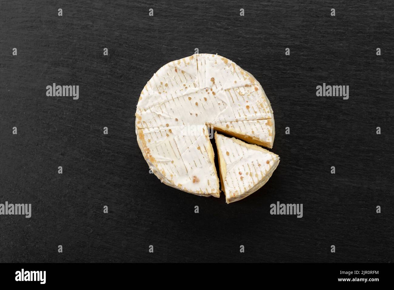 Brie type of cheese. Camembert cheese. Fresh Brie cheese and a slice on ...